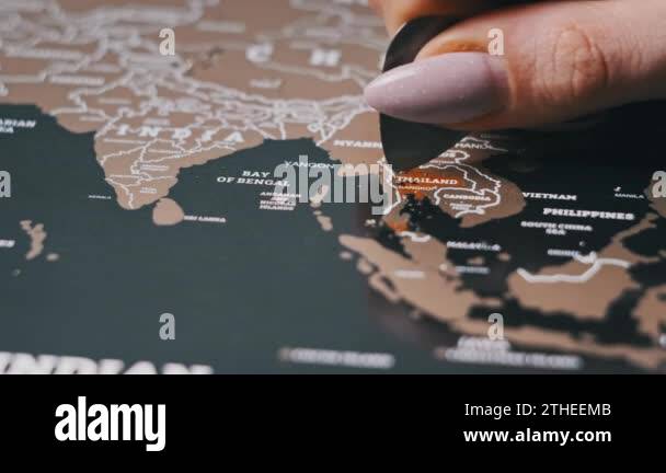Woman hand erases visited country of Thailand on the travel map ...
