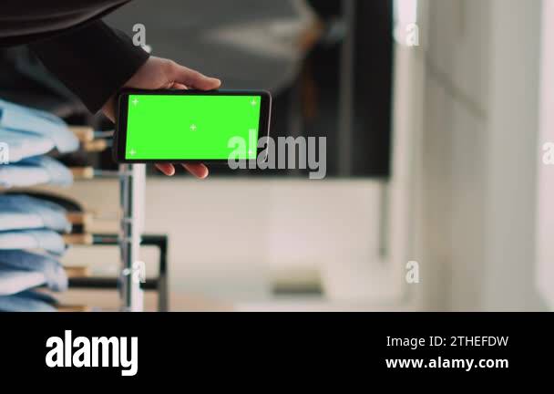 Vertical Video Young Assistant Using Blank Greenscreen Template Showing Chroma Key Display In