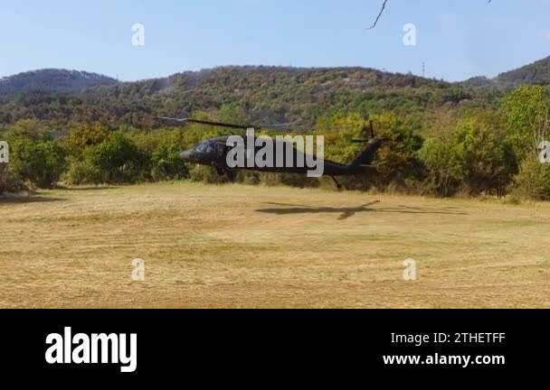 Military Black Hawk taking off grass field and flying overhead ...