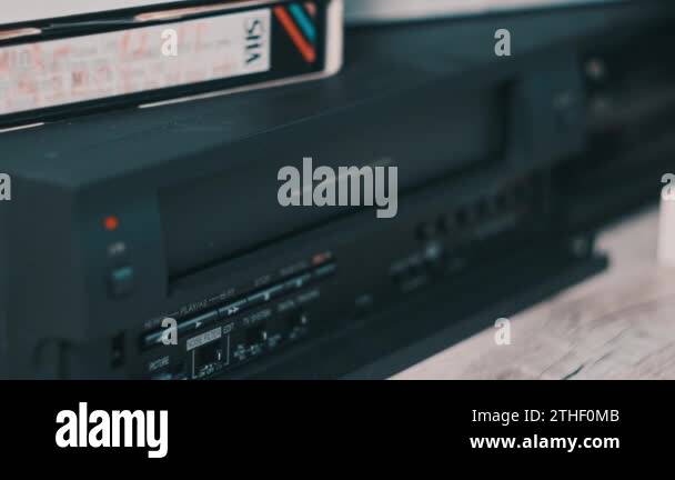 Insert VHS cassette into VCR player. Black vintage videotape cassette ...