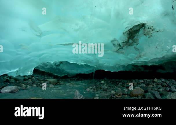 The ice under the rocks gradually melts and forms rivers. Turquoise ice ...