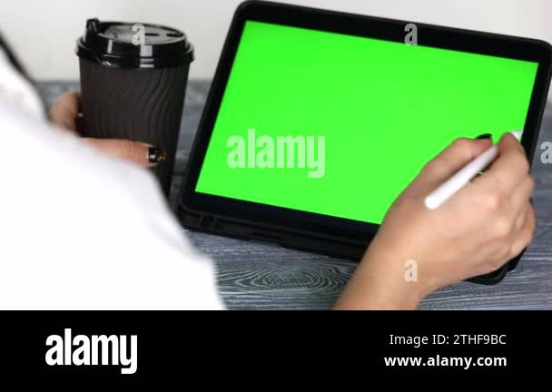 female hands swipe a finger on the green screen of the tablet Stock ...