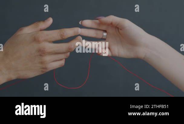 Two hands tied with red string touching fingers expressing love ...