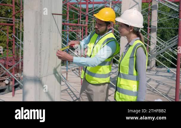 Engineer young man and woman using tape measure for check and examining ...
