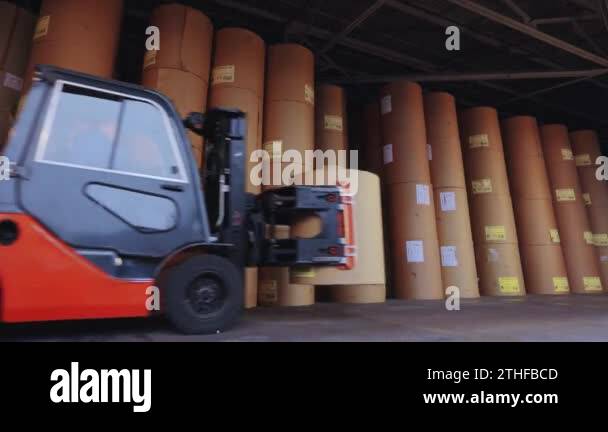 The forklift is carrying a large roll of paper. A forklift is carrying ...