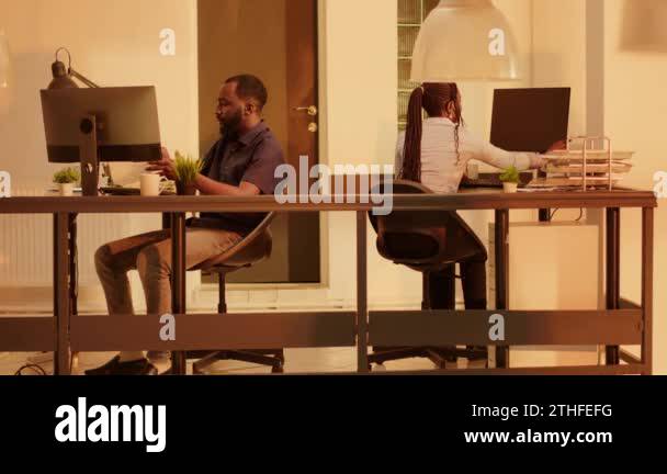 Company employee waving goodbye at coworker in office with big windows ...