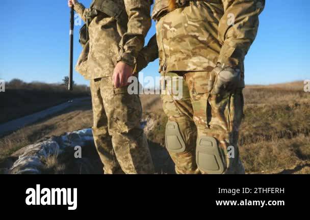 Young soldiers of ukrainian army standing at peak of hill with raised ...