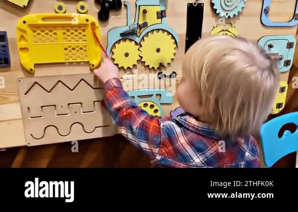 Child baby boy having fun playing with game busy board with spinning ...
