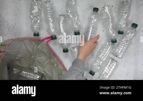 Hand getting plastic bottles to dispose in garbage bag ready to recycle ...