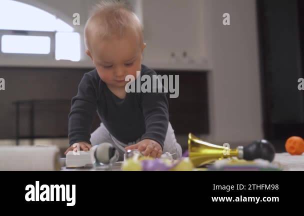 Close-up portrait shot of an excited baby boy playing with his colorful ...