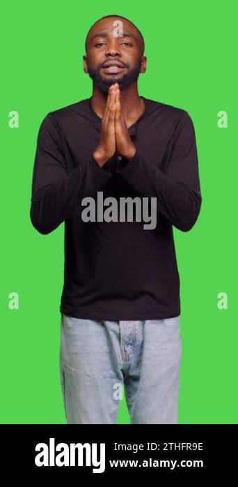 Vertical video: Front view of spiritual person praying to god in studio ...