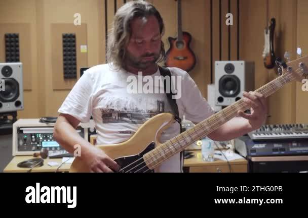 Bass guitar player in recording studio, front view, blurry background ...