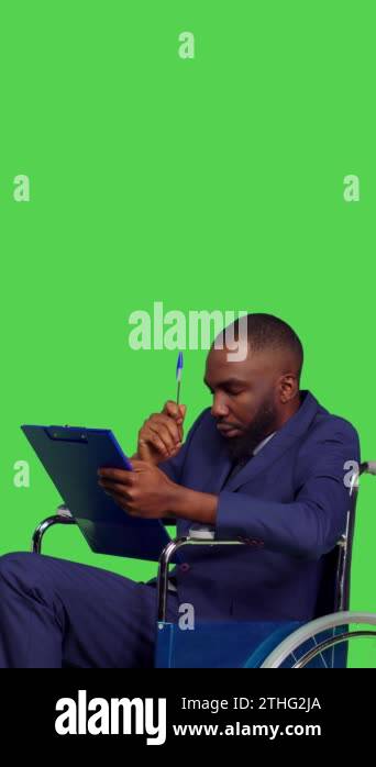 Vertical video: Side view of wheelchair user working with smartphone ...