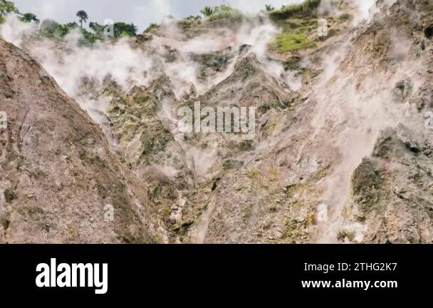 Volcanic activity on a mountainside with smoke and escaping gases. Slow ...