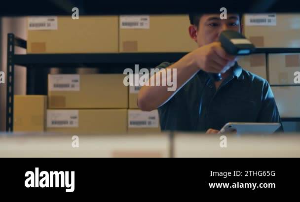 Asian businessman use barcode scanner scan paper box in shelf and put ...