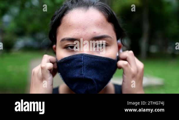 Woman removing face mask, happy hispanic girl taking off covid-19 face ...