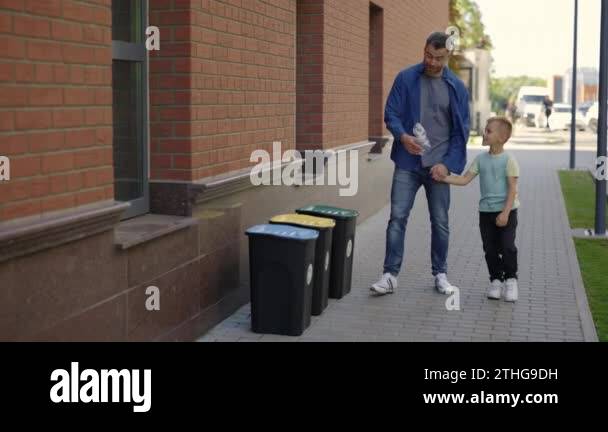 Dad teaches his son to properly sort garbage. Father and son sorting ...