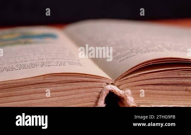 Female Fingers Leafing Through Pages of Old Shabby Book on a Black ...