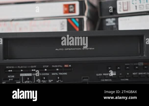 Insert VHS cassette into VCR. Black vintage videotape cassette recorder ...