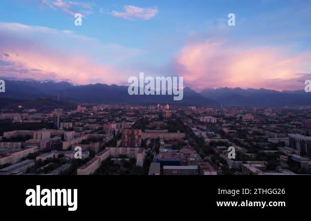 Pink-blue large clouds over the city of Almaty and the mountains. Top ...