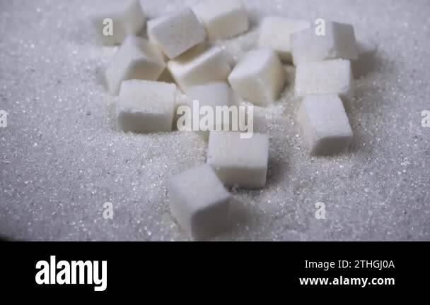 Refined Sugar Cubes Fall on the Surface of White Sugar. Close up. Slow ...
