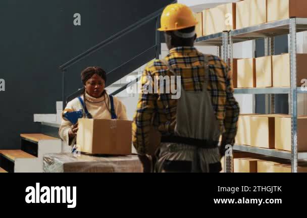 Team of employees preparing boxes with products in storehouse, packing ...
