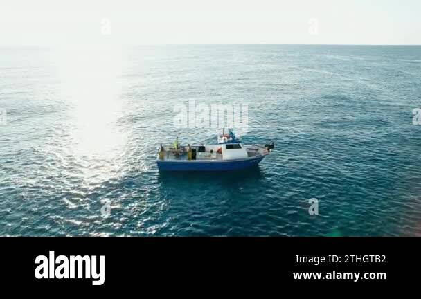 Three fishermen in the early morning pull out trawl net with sardines ...