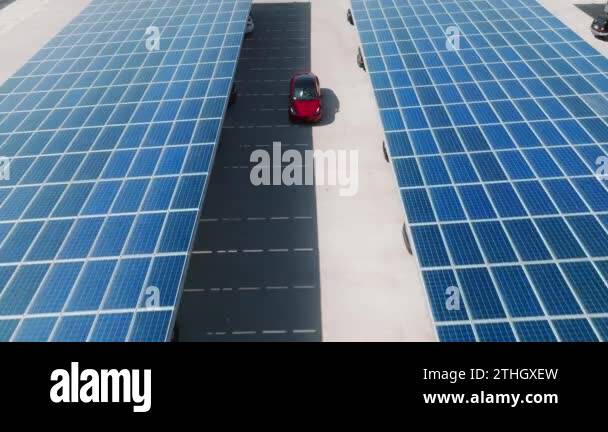 Aerial red electric car on rooftop parking with solar panels. Zero ...