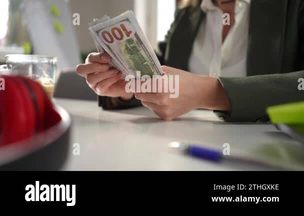 Female Caucasian hands counting cash dollars sitting at table indoors ...