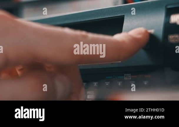 Eject VHS tape cassette from VCR player. Male hand pushes a button and ...