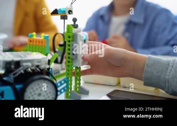 Robotics programming class. Children construct and code Robot. STEM education using constructor ...