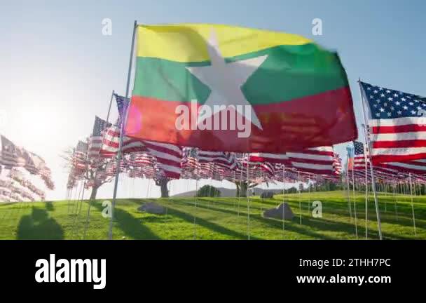 Flag of Myanmar or Burma waving in wind with many American flags on ...