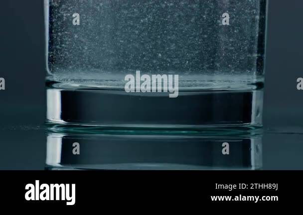 Closeup fizzy water bubbling in glass. Diverse acid bubbles rising ...