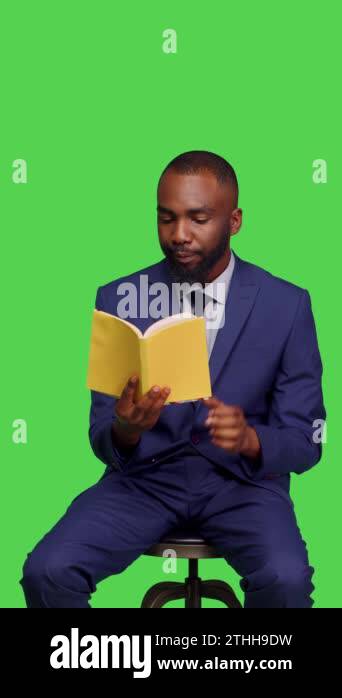 Vertical video: Front view of african american person reading pages of ...