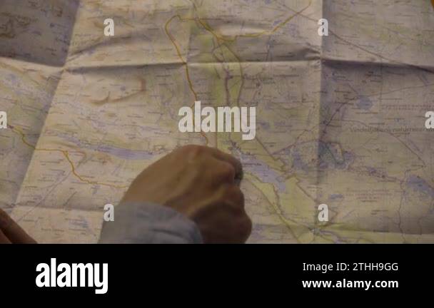 a hand is showing different trails on a big paper map on the alps Stock ...