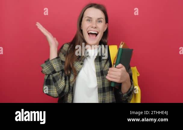Cheerful young pretty student woman holding books feeling happy and ...