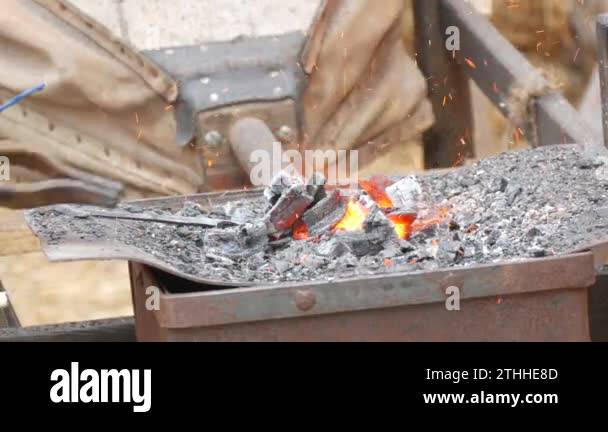 Medieval method of forging iron, the blacksmith forges an iron nail ...