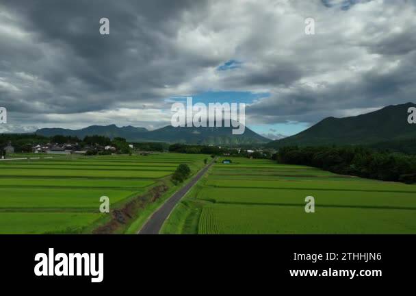 Takeoff from country road through rice fields at foot of Mt. Daisen on cloudy day. High quality ...