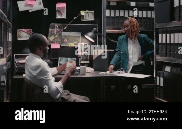 Inspectors team talking about suspicious photos in incident room ...