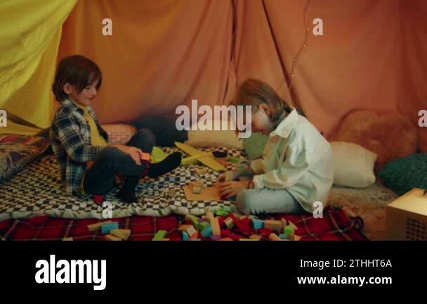 Two younger boys are smiling and laughing with eachother while throwing ...