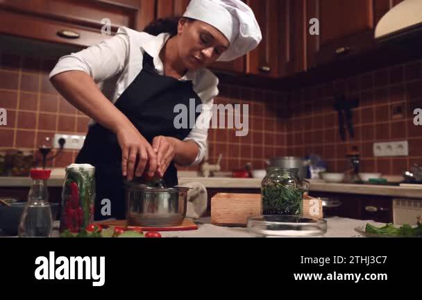 Multi-ethnic beautiful young woman, housewife in white chefs hat and ...
