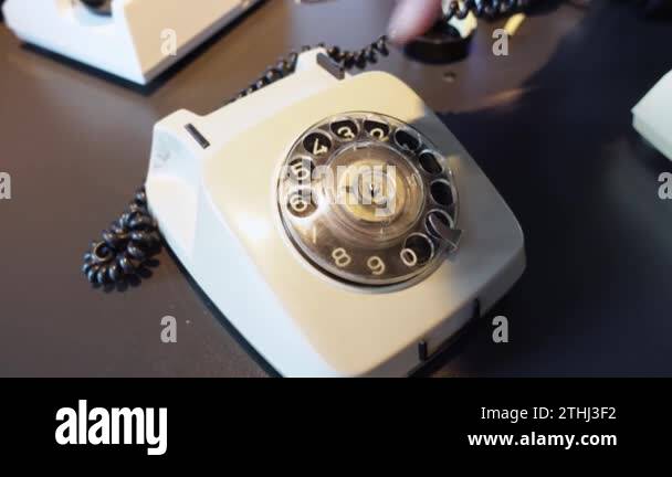 Mans hand removing the Handset, rotating the Dialer on an Old white ...