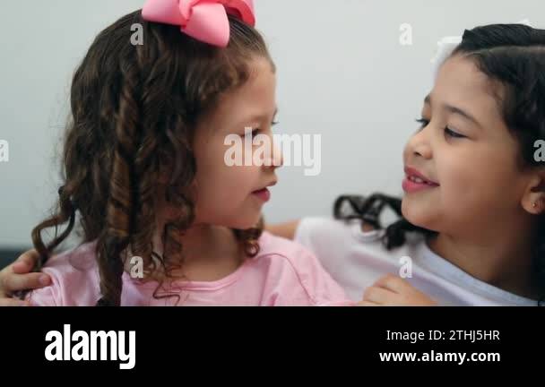 Two little sisters in conversation, small children talking to each ...