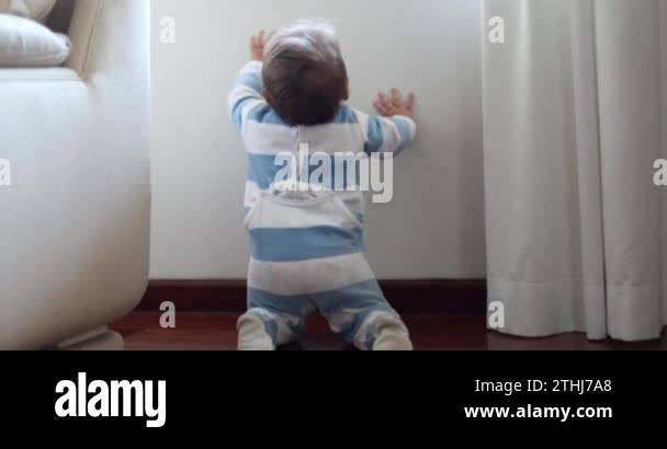 Cute baby boy standing up at home. Infant child learning development ...