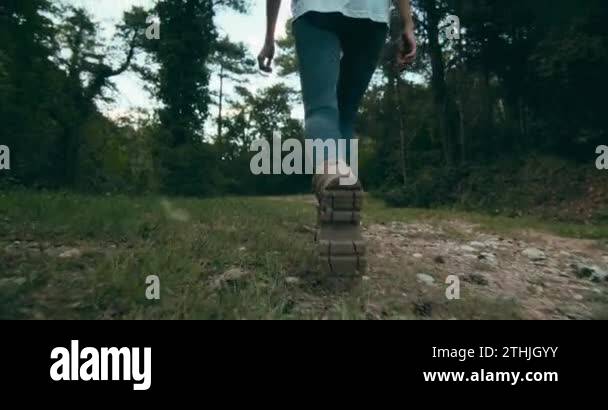 Low angle slow motion footage of young adult unrecognizable woman walk ...