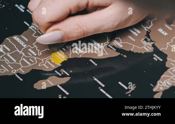 Scratching country of Tanzania on the surface of a scratch world map ...