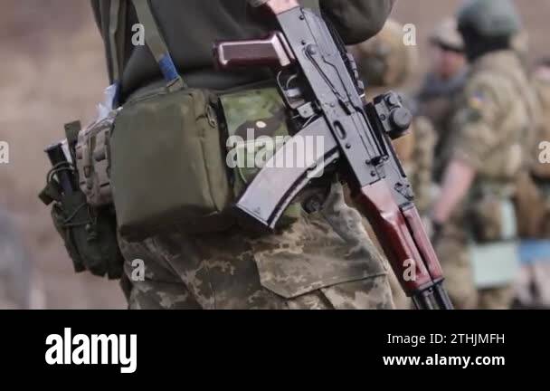 At a checkpoint at a military base, an armed soldier with a submachine ...