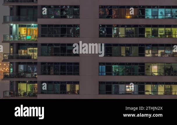 Windows lights in modern apartment buildings timelapse at night. Multi ...
