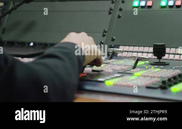 Employee switching images from camera to camera by vision mixer against ...