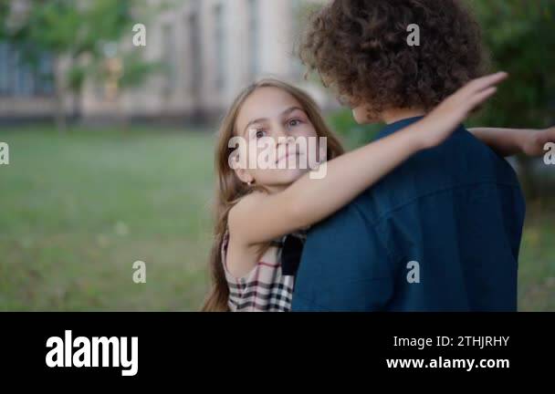 Pretty girl hugging boy in slow motion rolling eyes looking at camera ...